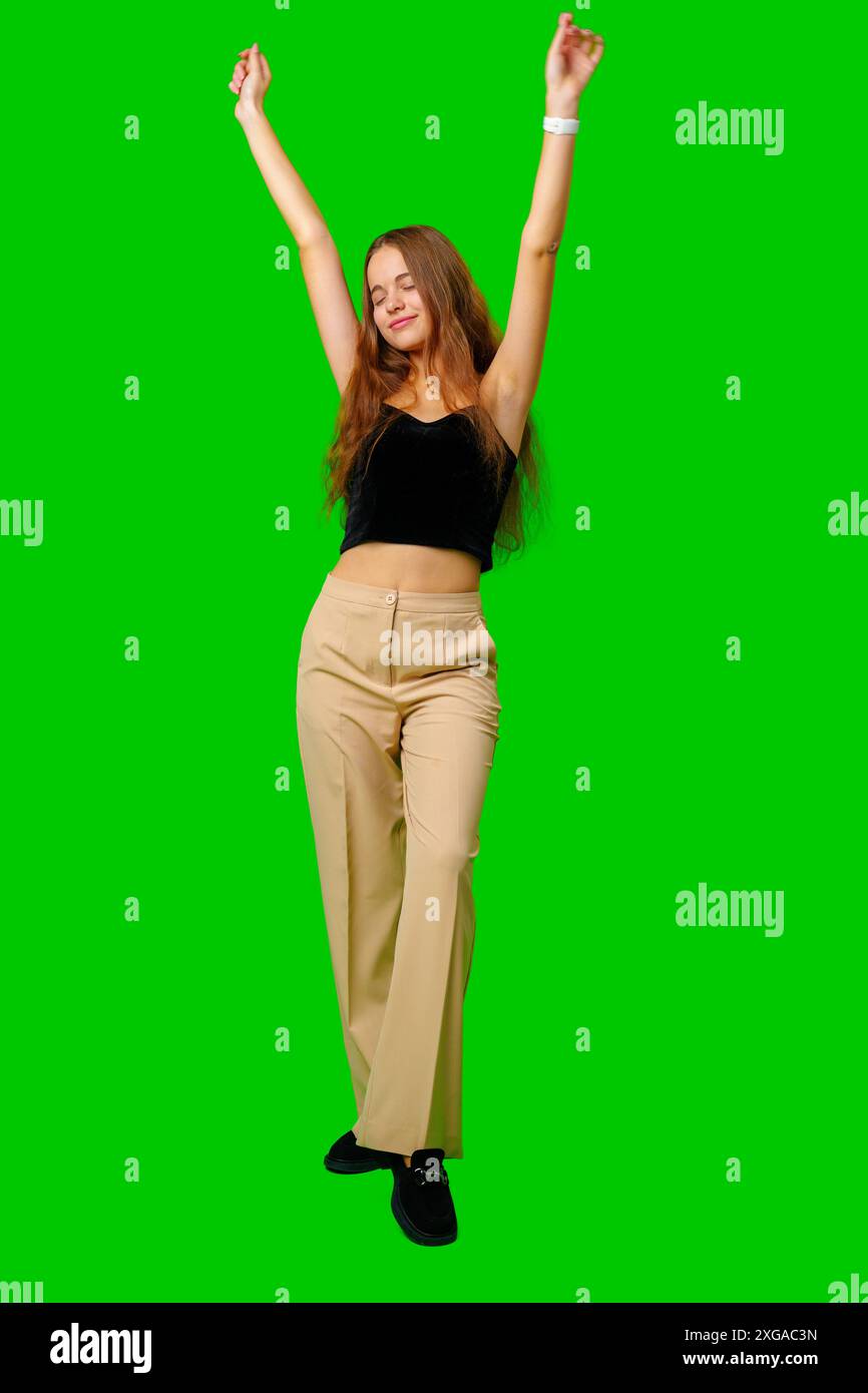 Young Woman Celebrating Success With Raised Fists Against Green Screen ...