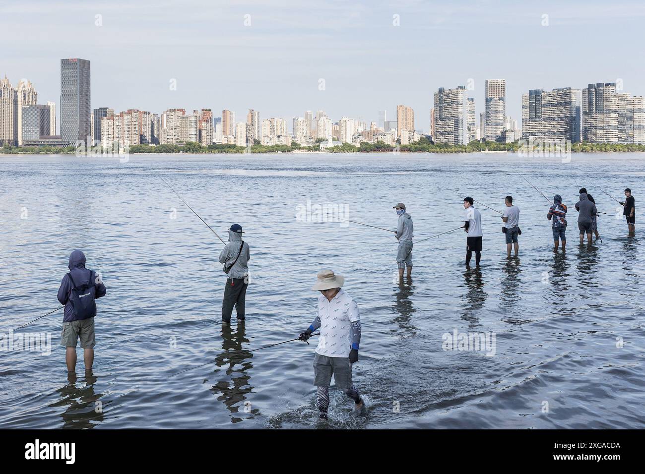 Wuhan, China. 07th July, 2024. People seen fishing in the flooded ...