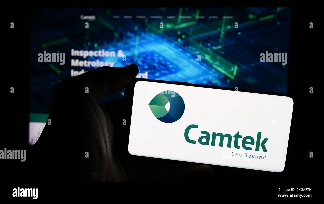 Person holding mobile phone with logo of Israeli metrology equipment ...