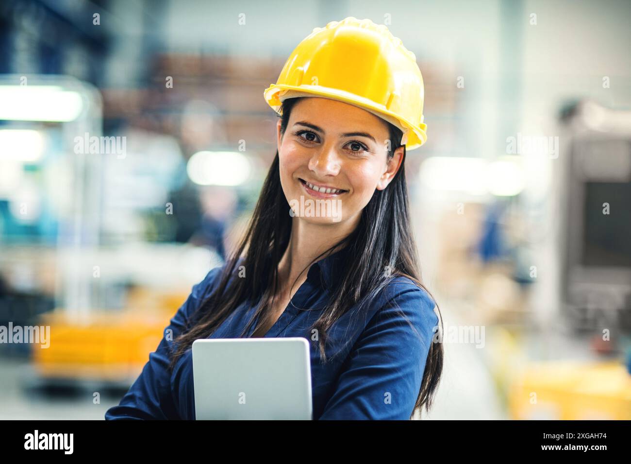 Female project manager standing in modern industrial factory, holding ...