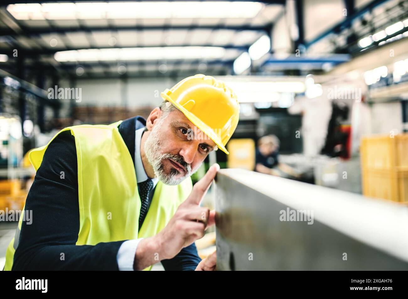 Portrait of engineer controlling machine in modern industrial factory ...