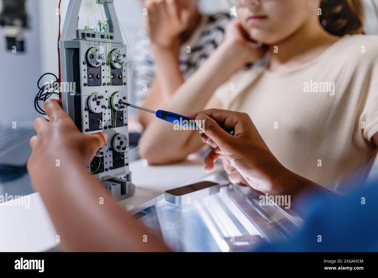 Two classmates working together on circuit board, building robot in ...