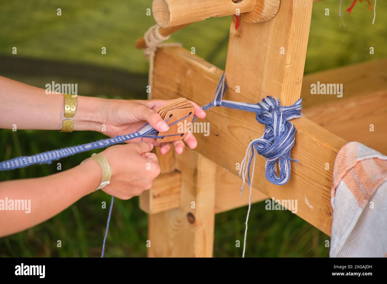 A reenactment of traditional weaving features a person in historical ...