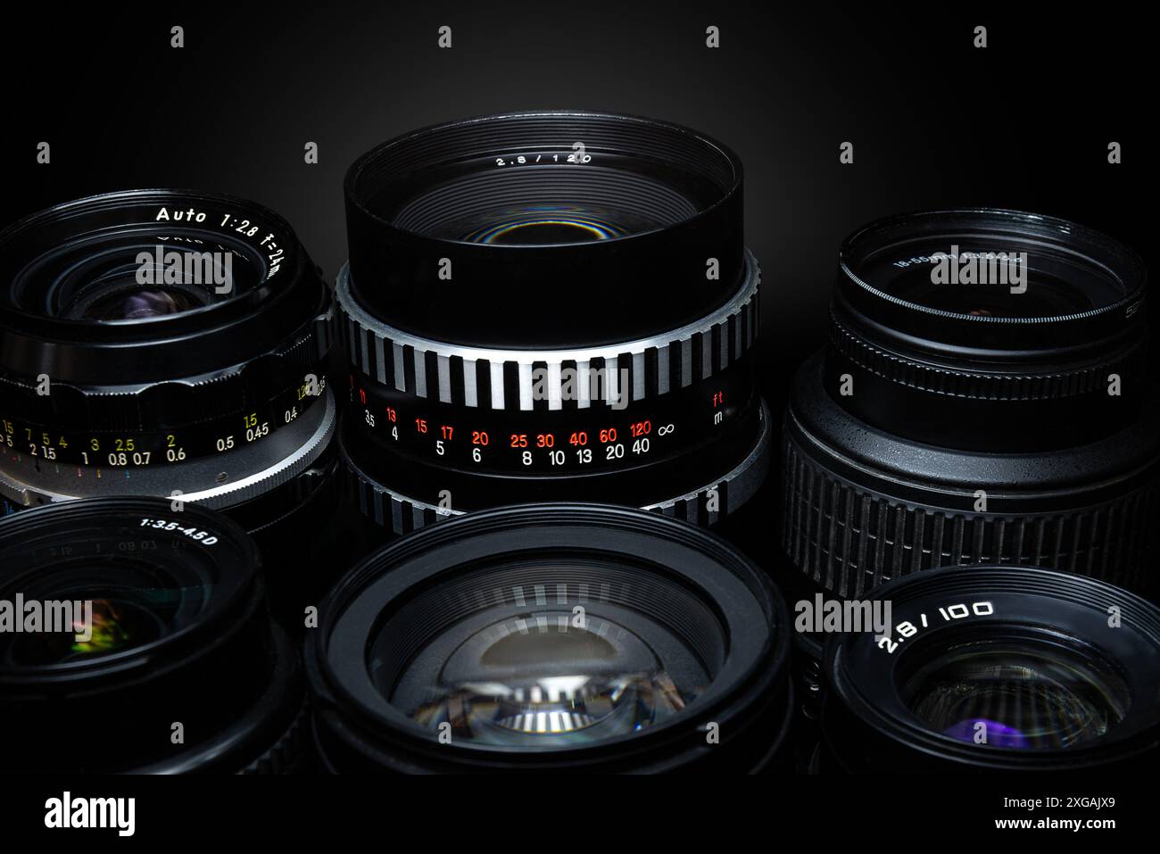 A diverse group of camera lenses, ranging from vintage manual focus to ...