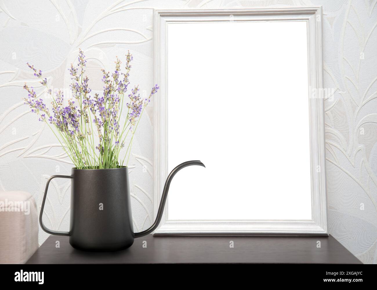 A black kettle with lavender flowers sits on a table next to a white ...