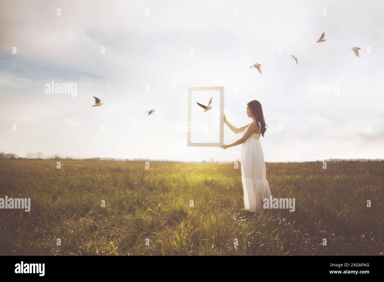 woman holds a surreal window through which a group of birds pass by ...