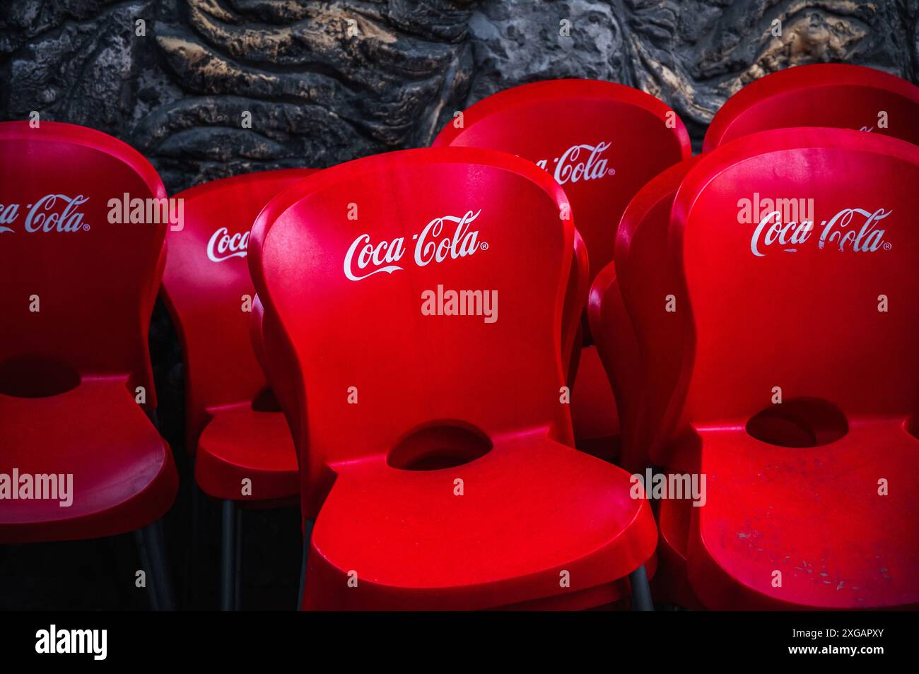 red chairs with Coca-Cola advertising symbols in an outdoor cafe in the ...