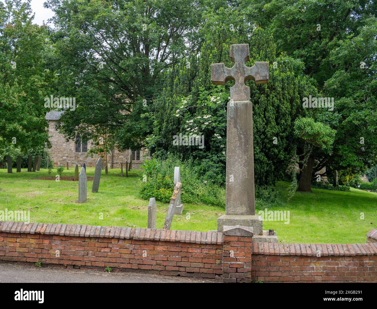 Tall memorial cross in the churchyard of All Saints in the village of ...