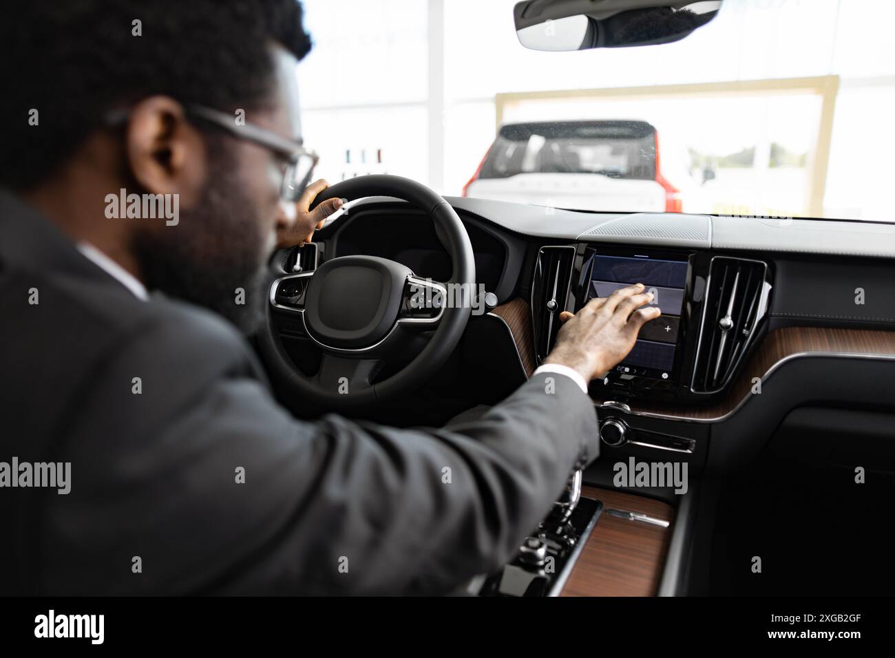 Businessman exploring car features at dealership in showroom Stock ...