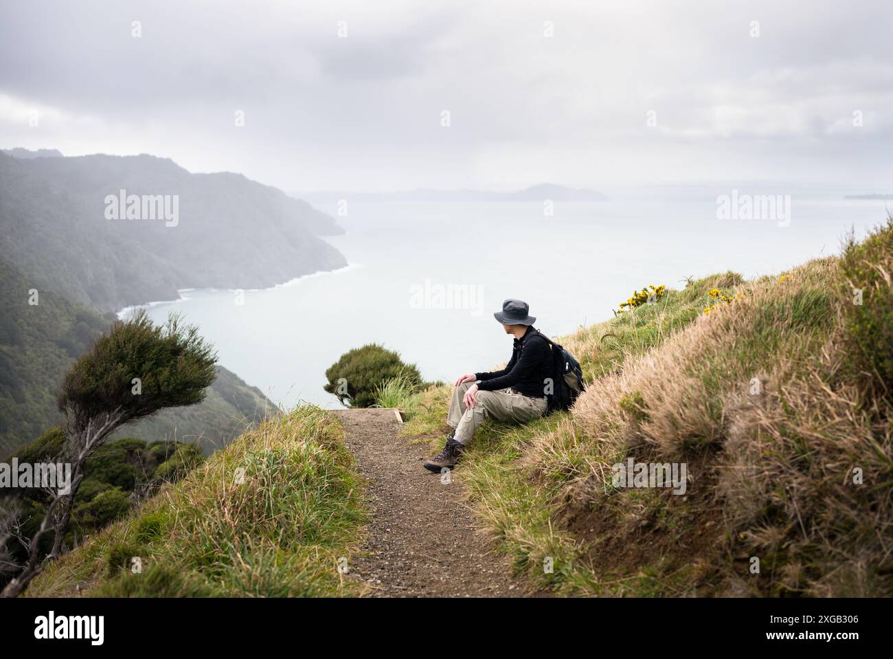 Man sitting on the side of the track and enjoying the views. Omanawanui ...