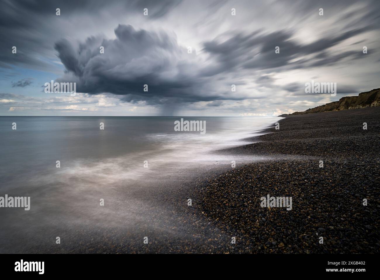 Storm cloud passing over the shingle beach at Weyborne beach, Norfolk ...