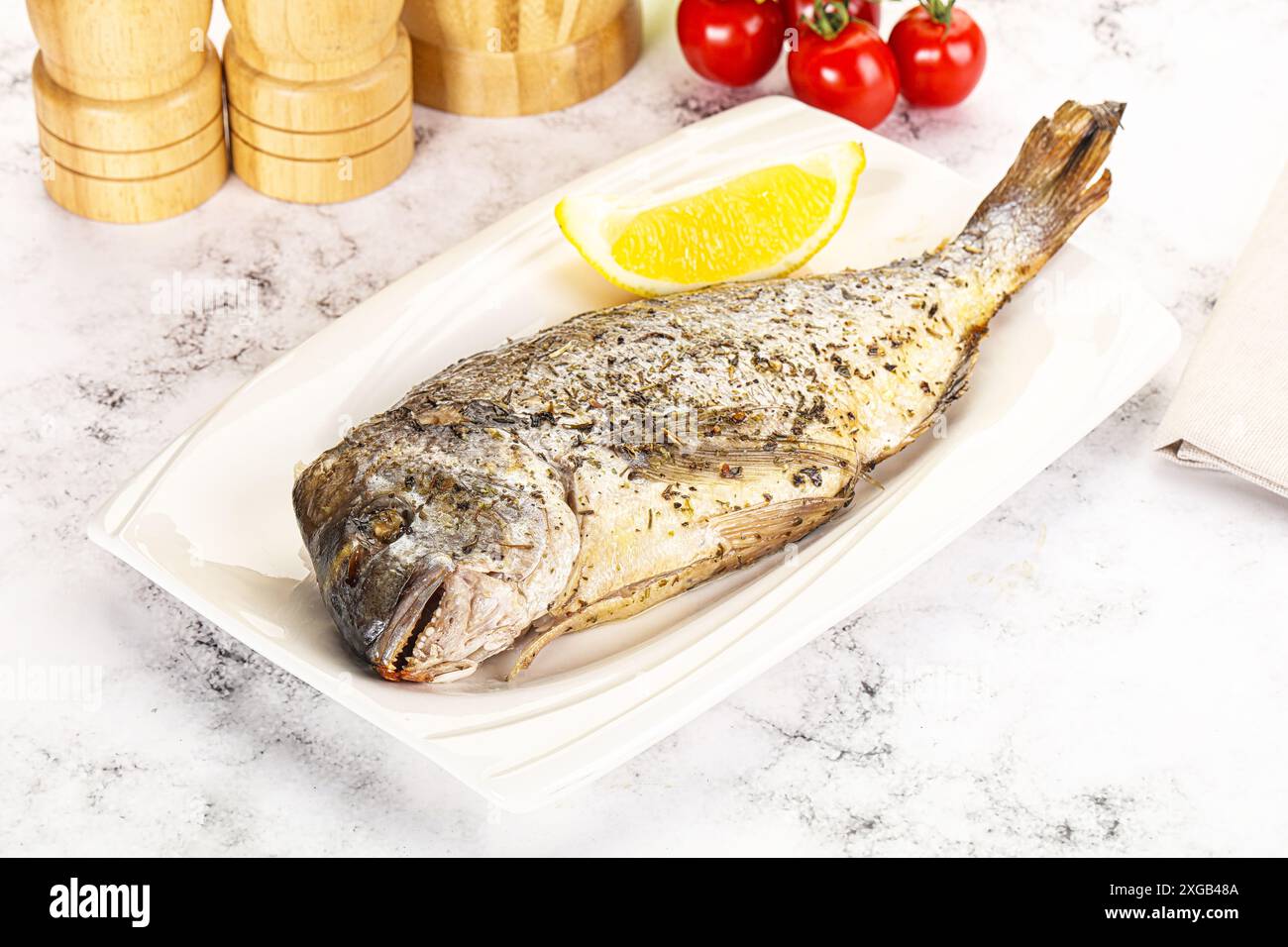 Baked Dorado fish served lemon slice Stock Photo - Alamy