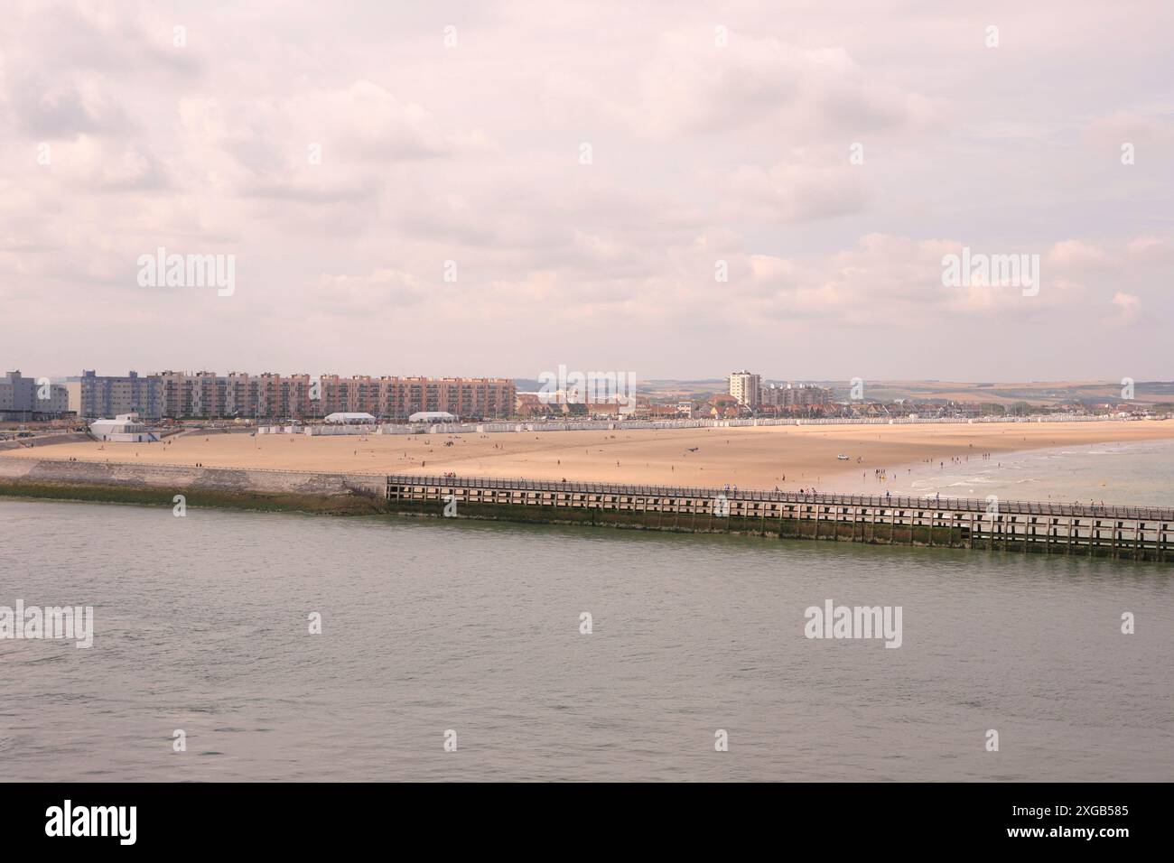 A pier and wave break guard the entrance to the port of Calais, France ...