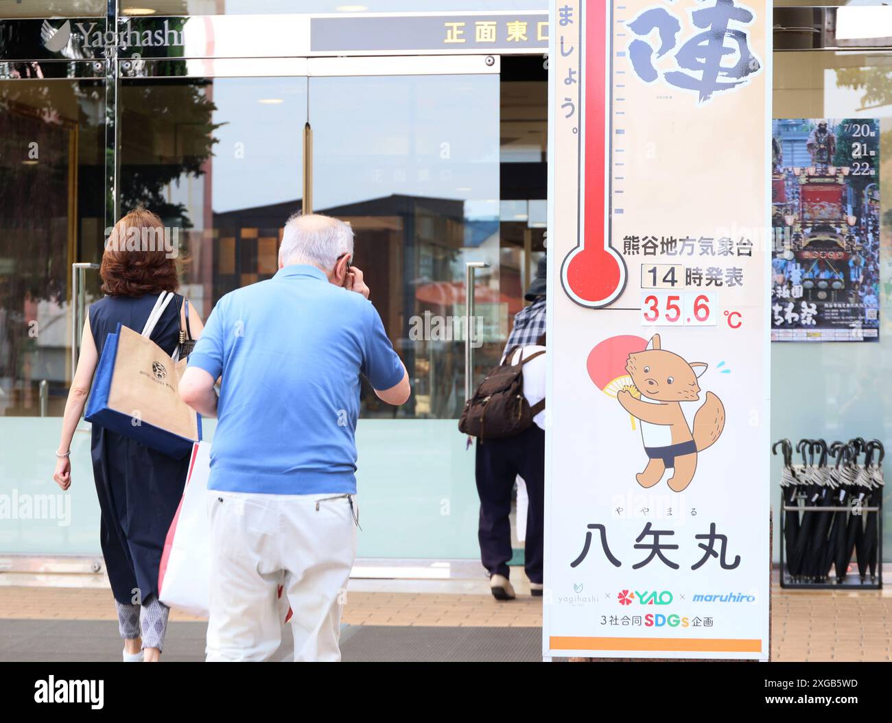July 8, 2024, Tokyo, Japan - Shoppers pass a large thermometer which is ...