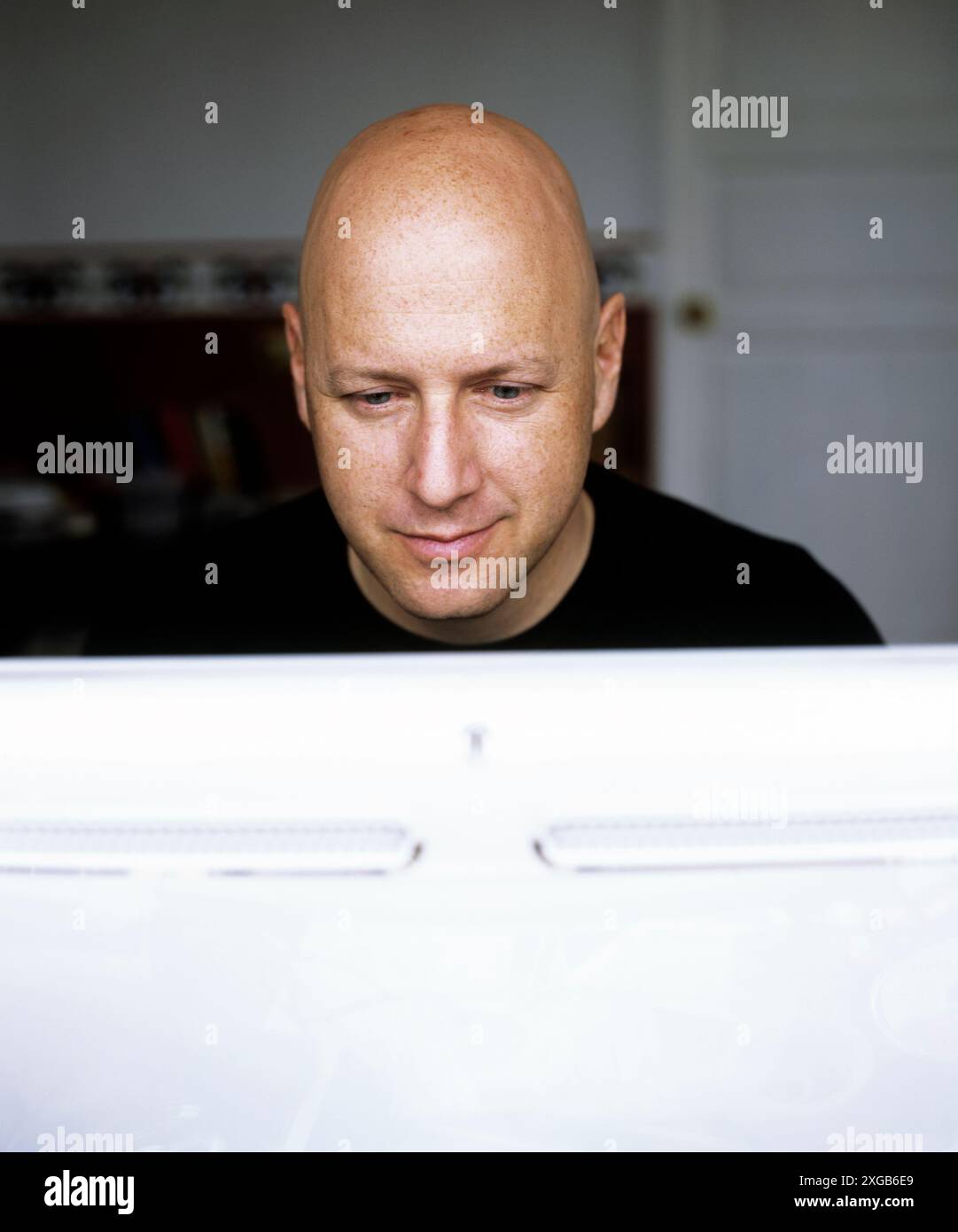 A bald headed man working on a computer in Mexico Stock Photo - Alamy