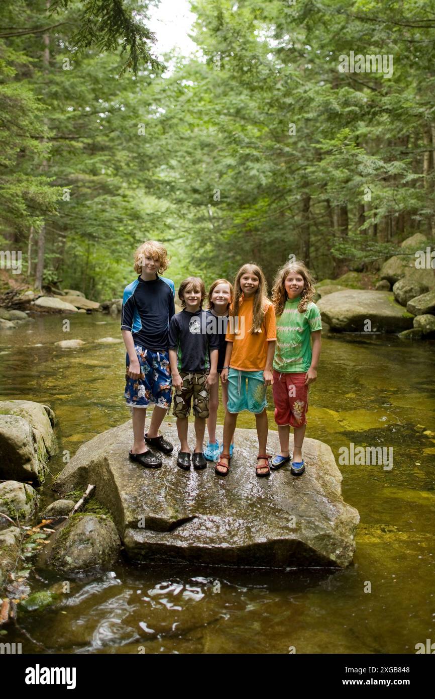 A group of children, ages 6-10, stand on a rock in a river in the White ...