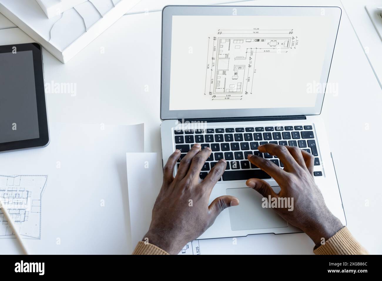 Man architect working with software on laptop using technical drafts ...