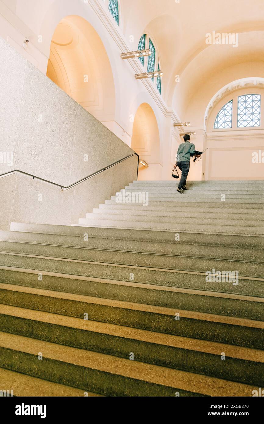 Man Walking Up Stairs in a Large Building With Arched Ceilings Stock ...