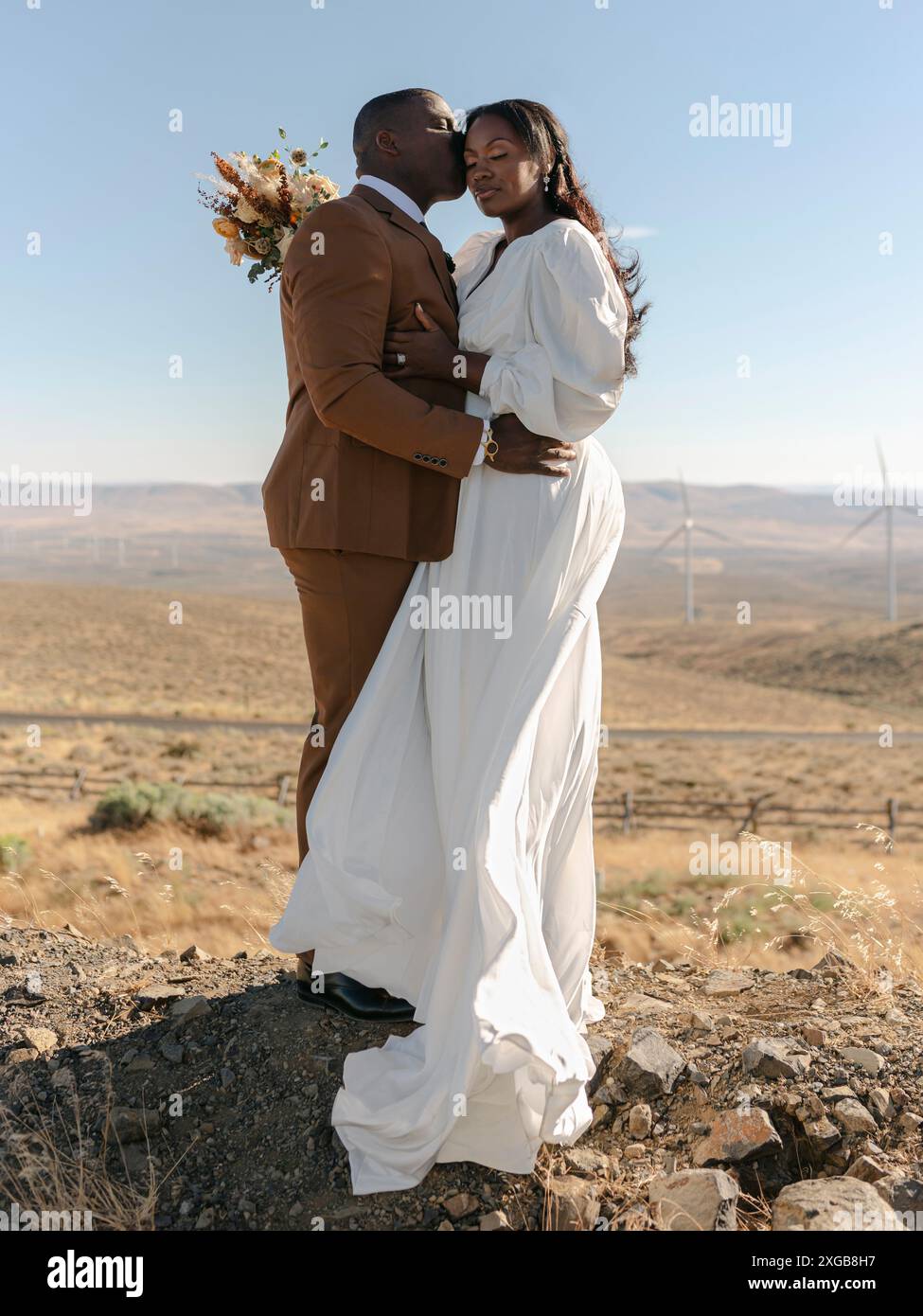Husband and wife embracing on a solar wind turbine farm Stock Photo - Alamy