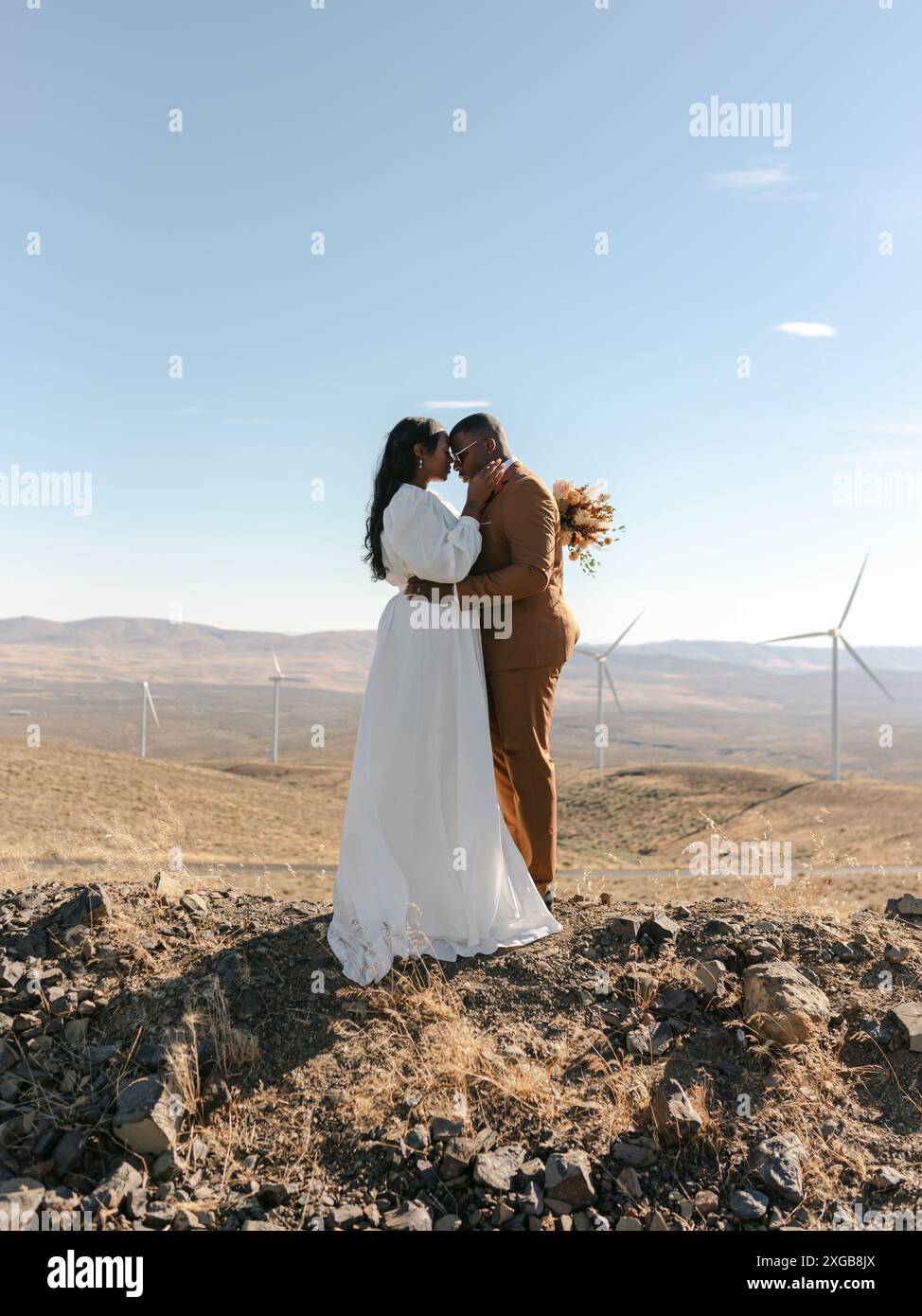 Husband and wife embracing on a solar wind turbine farm Stock Photo - Alamy