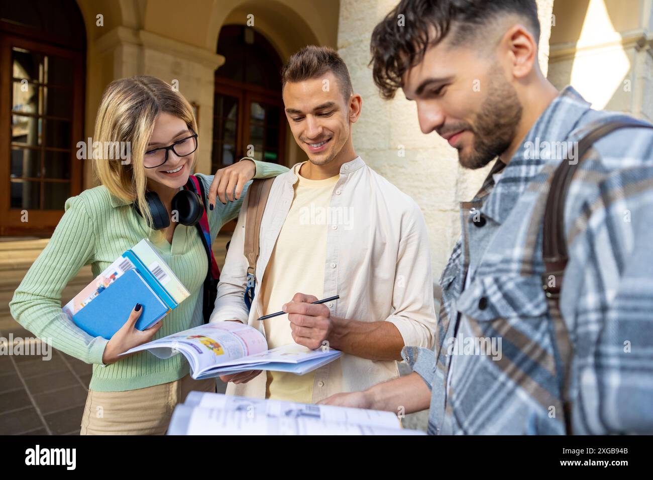 Joyful students with books standing in collage campus Stock Photo - Alamy