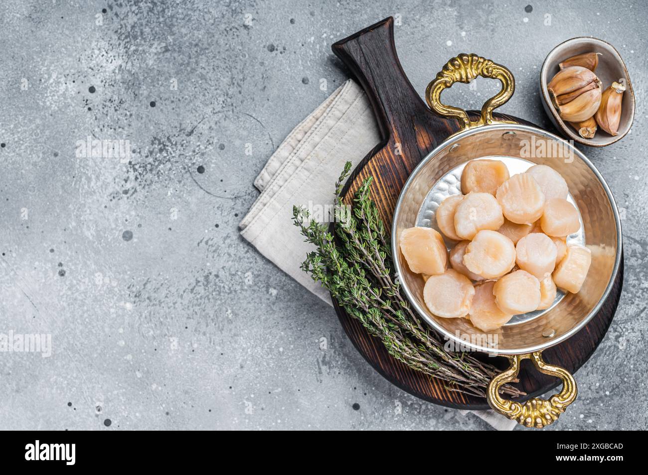 Raw sea scallops fillets in a skillet. Gray background. Top view. Copy ...