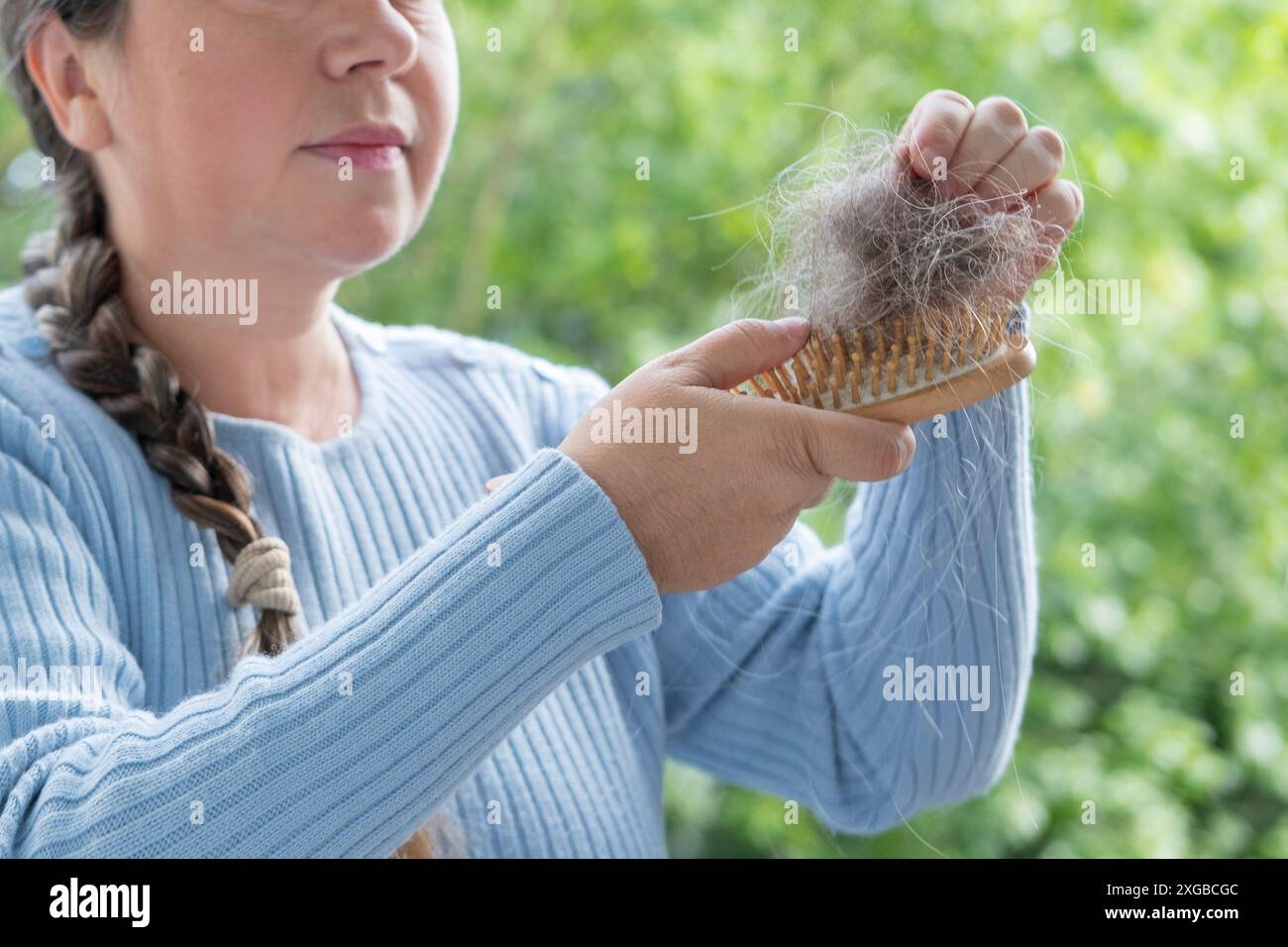 wooden comb, brush in female hand, woman combing long brown hair ...