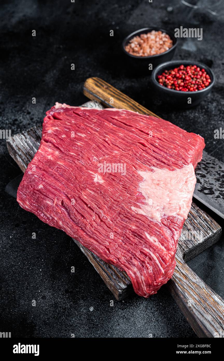 Uncooked Raw beef brisket meat on butcher board. Black background. Top ...