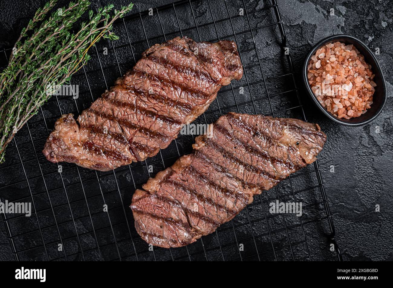 Grilled denver beef meat steak on a rack. Black background. Top view ...