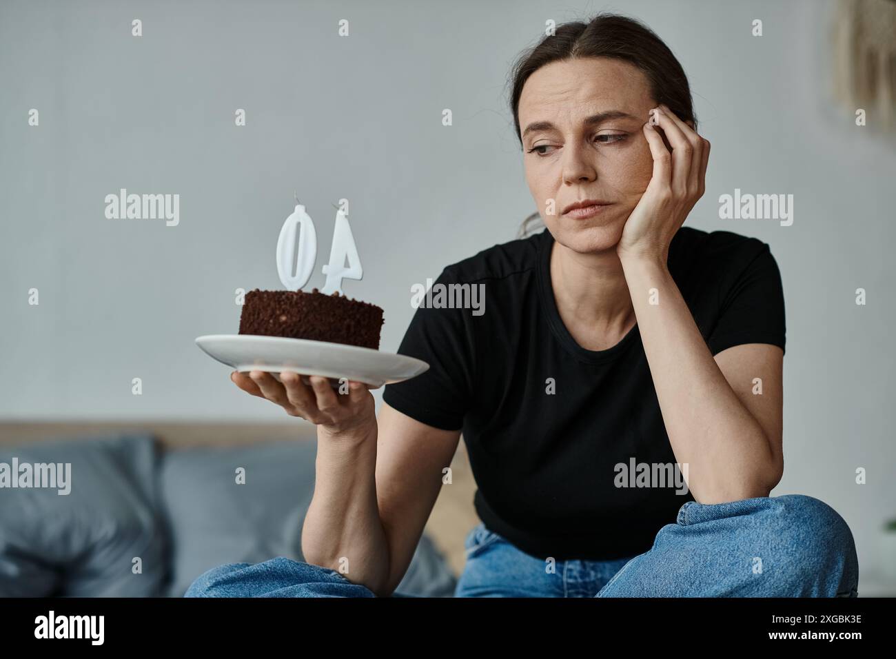 Woman holding a cake with the number 40 on it, celebrating a milestone ...