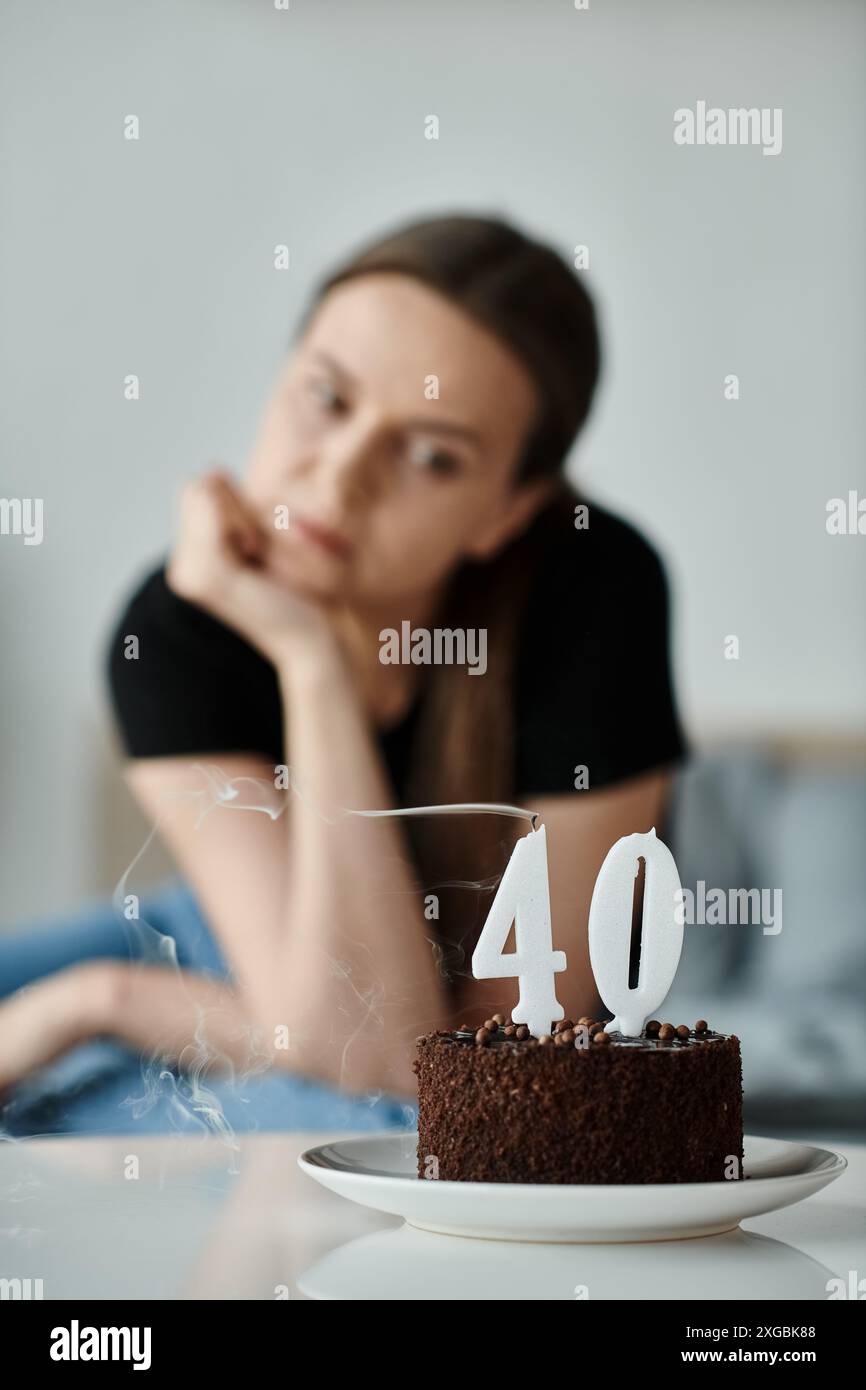 Middle-aged woman gazes at a birthday cake, pondering the significance ...