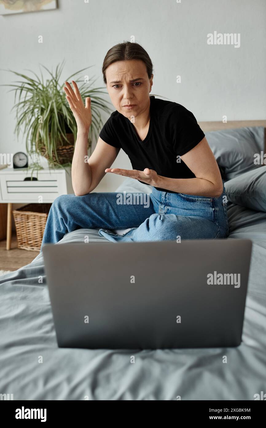 Woman sits on bed with laptop, seeking solace in virtual therapy Stock ...