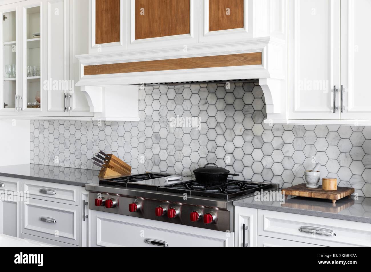 A kitchen range detail with a marble hexagon tile backsplash, white ...