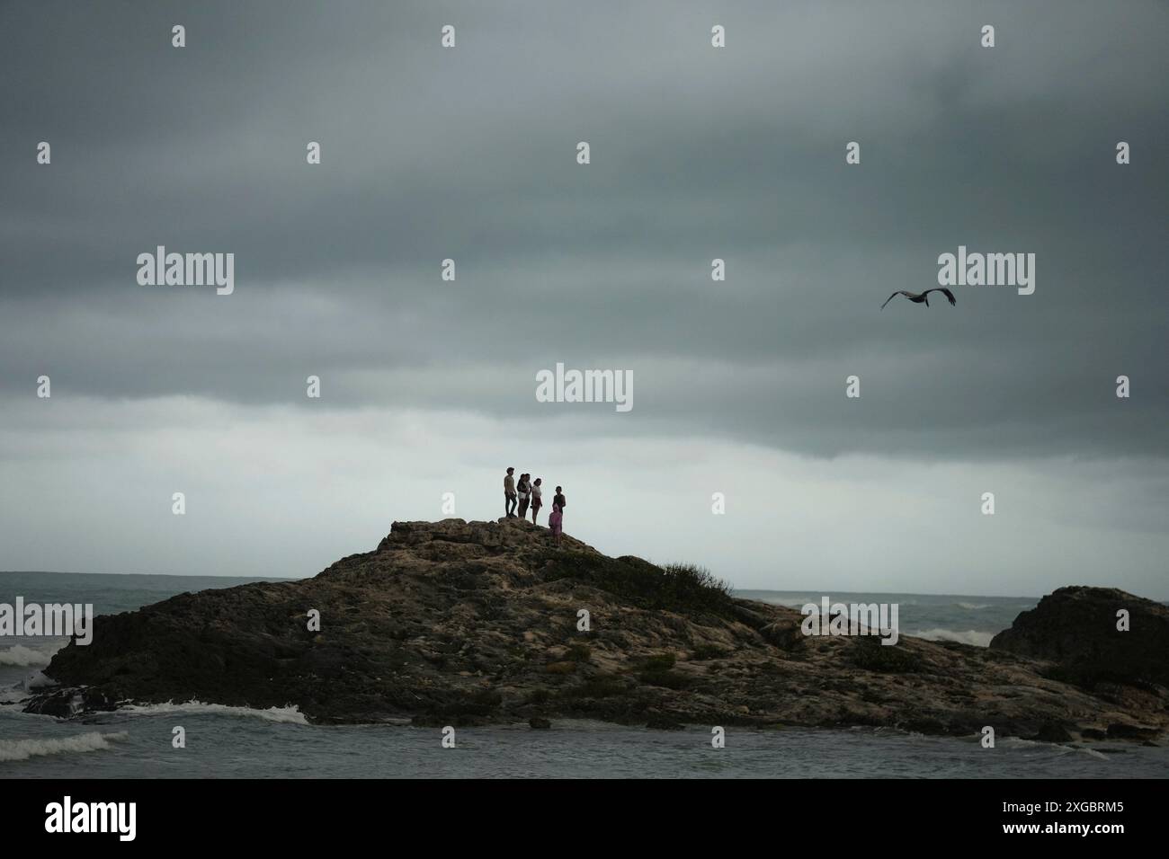 FILE - People stand on a rocky outcrop in the aftermath of Hurricane ...