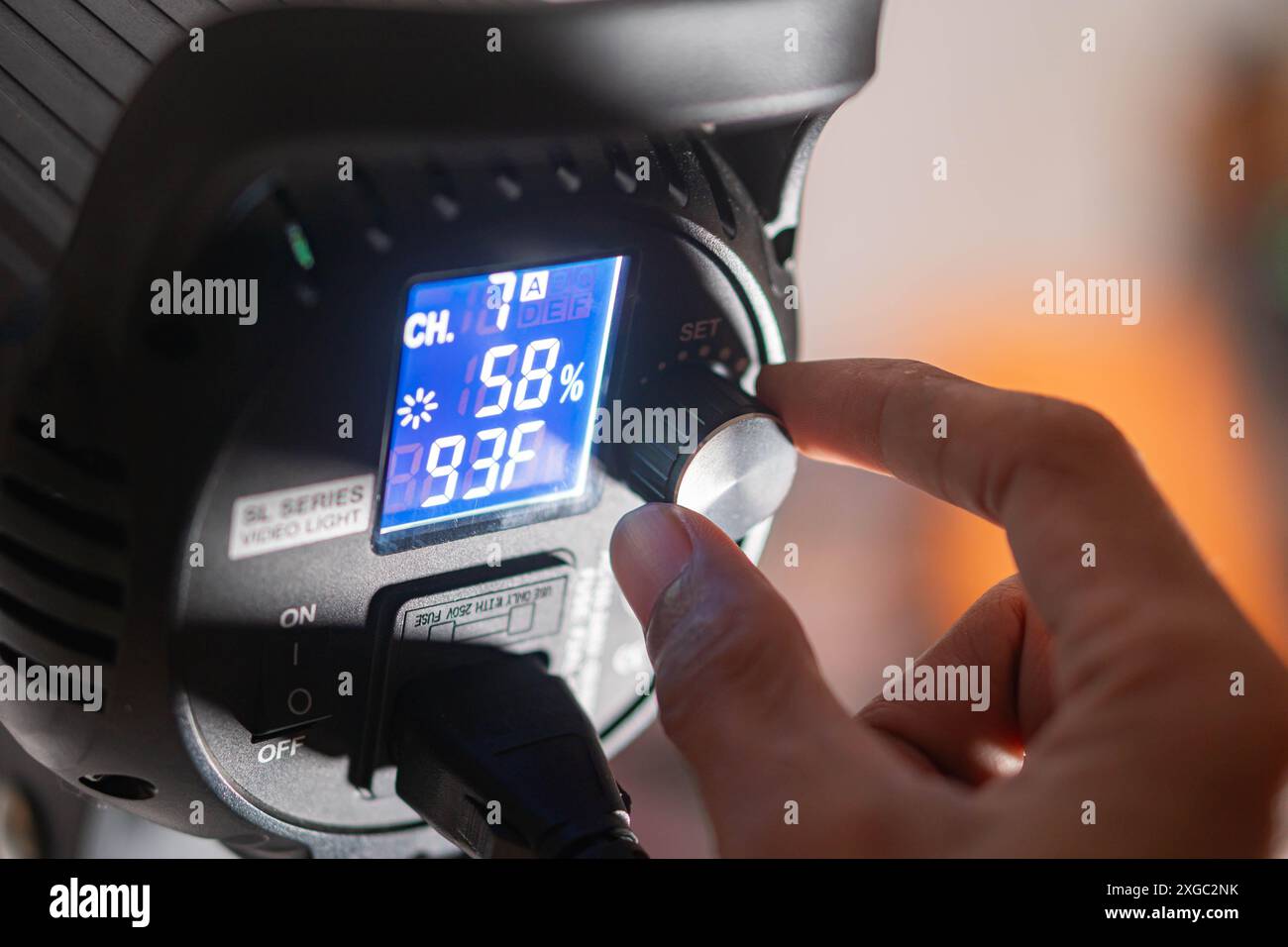 Close-up of a hand adjusting the settings on a digital display of a ...