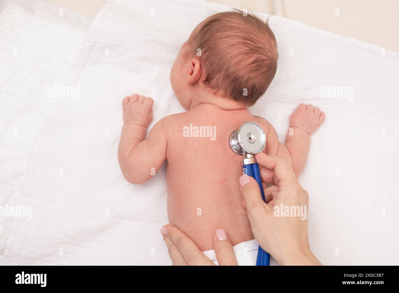 Newborn medical exam - doctor checking heart beat and lungs with ...