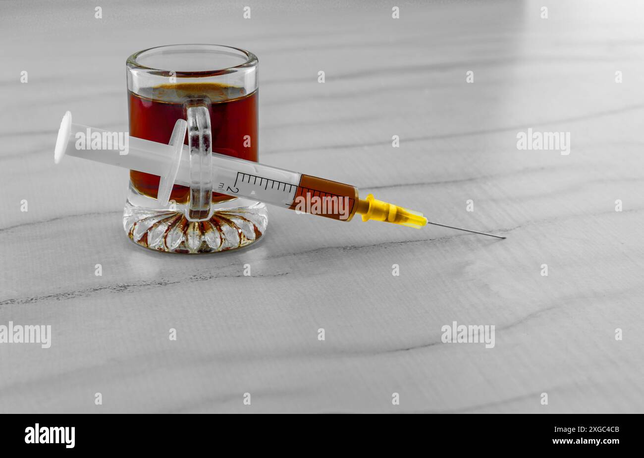 Glass with alcohol on the table, syringe for administering medicines ...