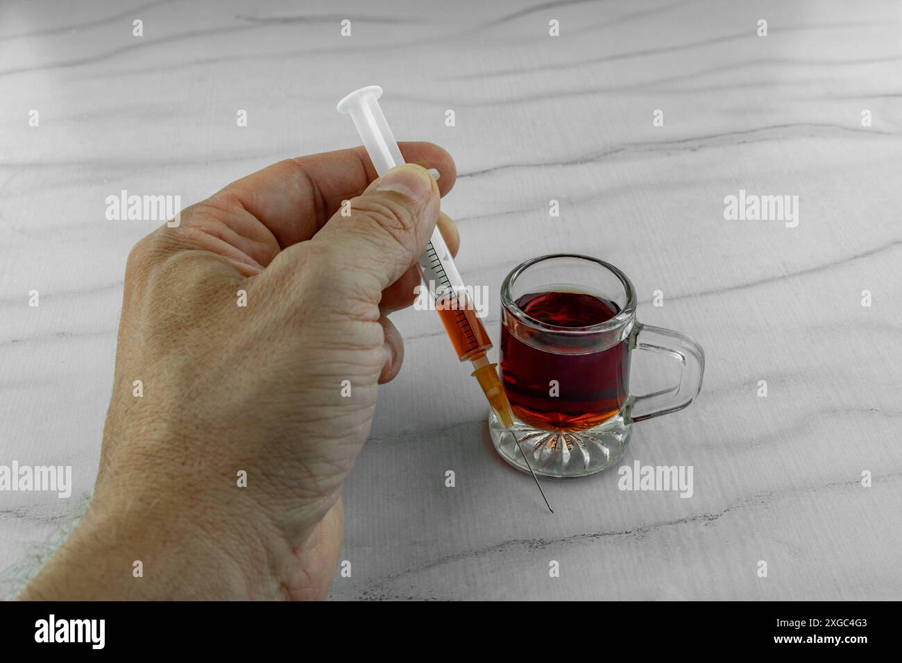 Glass with alcohol on the table, syringe for administering medicines ...