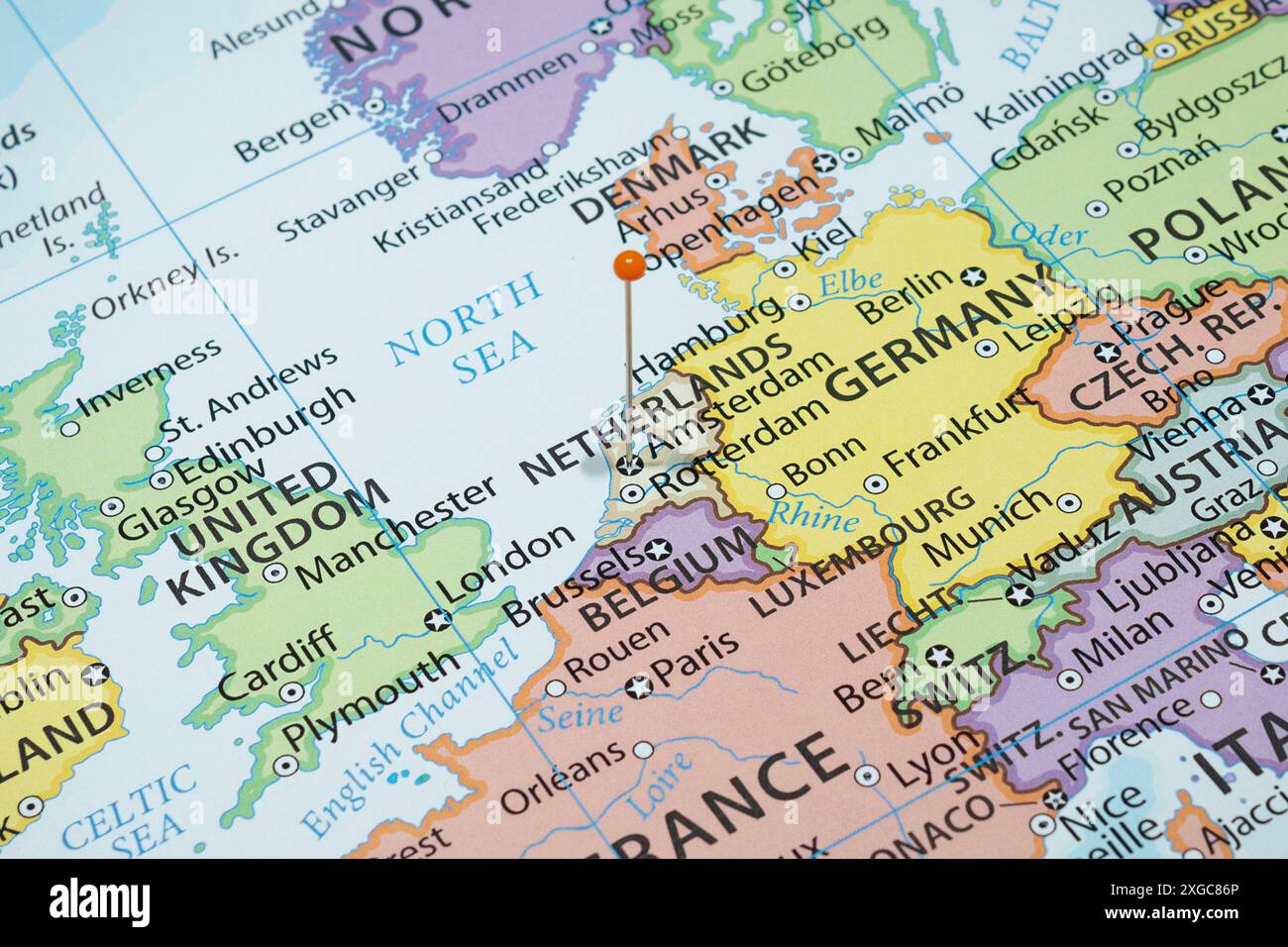 Close up to a Amsterdam city with an orange pin needle into netherlands ...