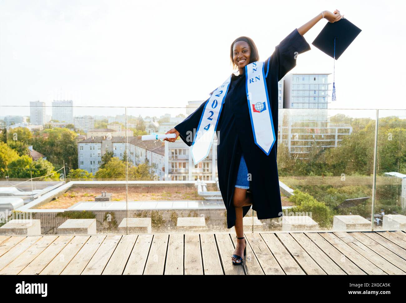graduates in mantles, throwing up graduation caps Stock Photo - Alamy