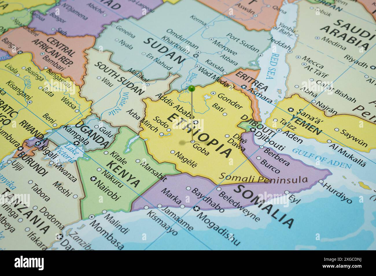 Close up to a Goba city with a green pin needle into Ethiopia country ...