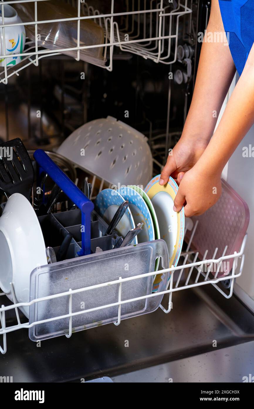 Children's hands load dirty dishes into the dishwasher Stock Photo - Alamy