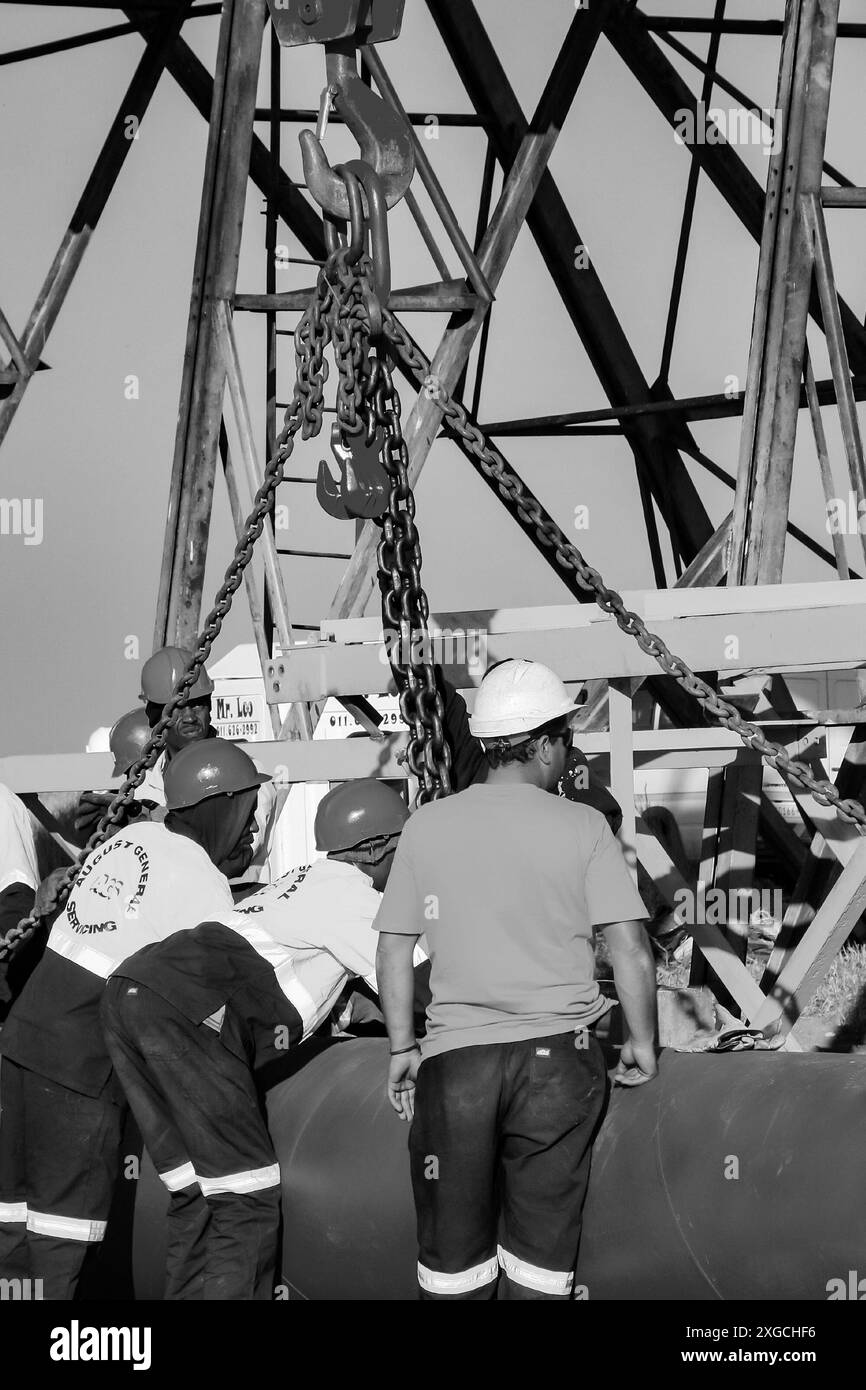 A black and white vertical footage of construction workers handling ...