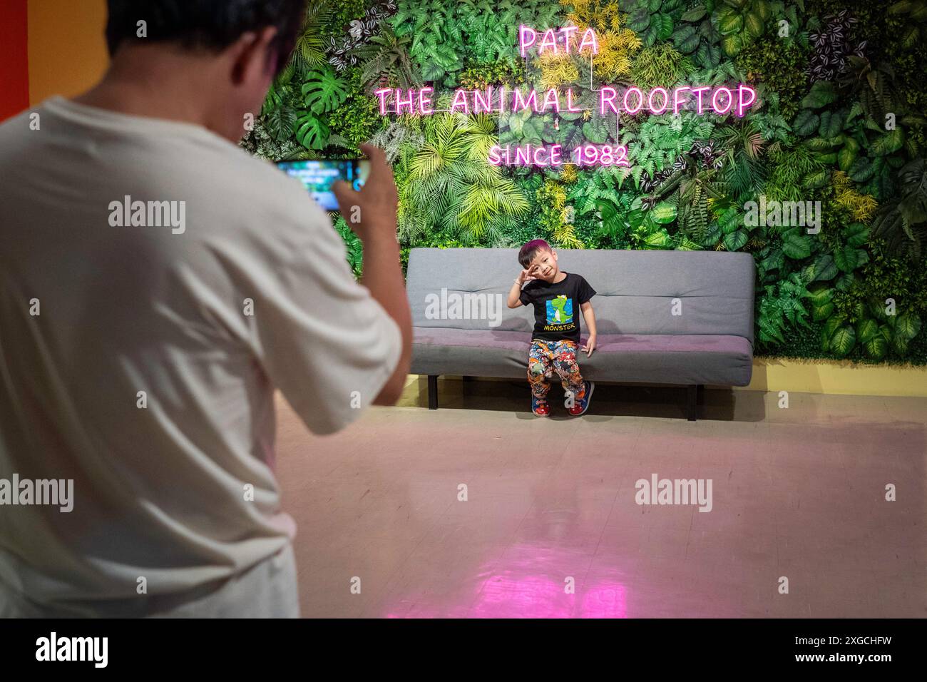 A father is seen taking a photos of his son, at Pata Exotic Studio, on ...