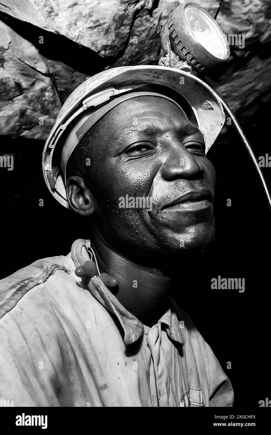 A grayscale vertical portrait of African worker wearing Safety Helmet ...