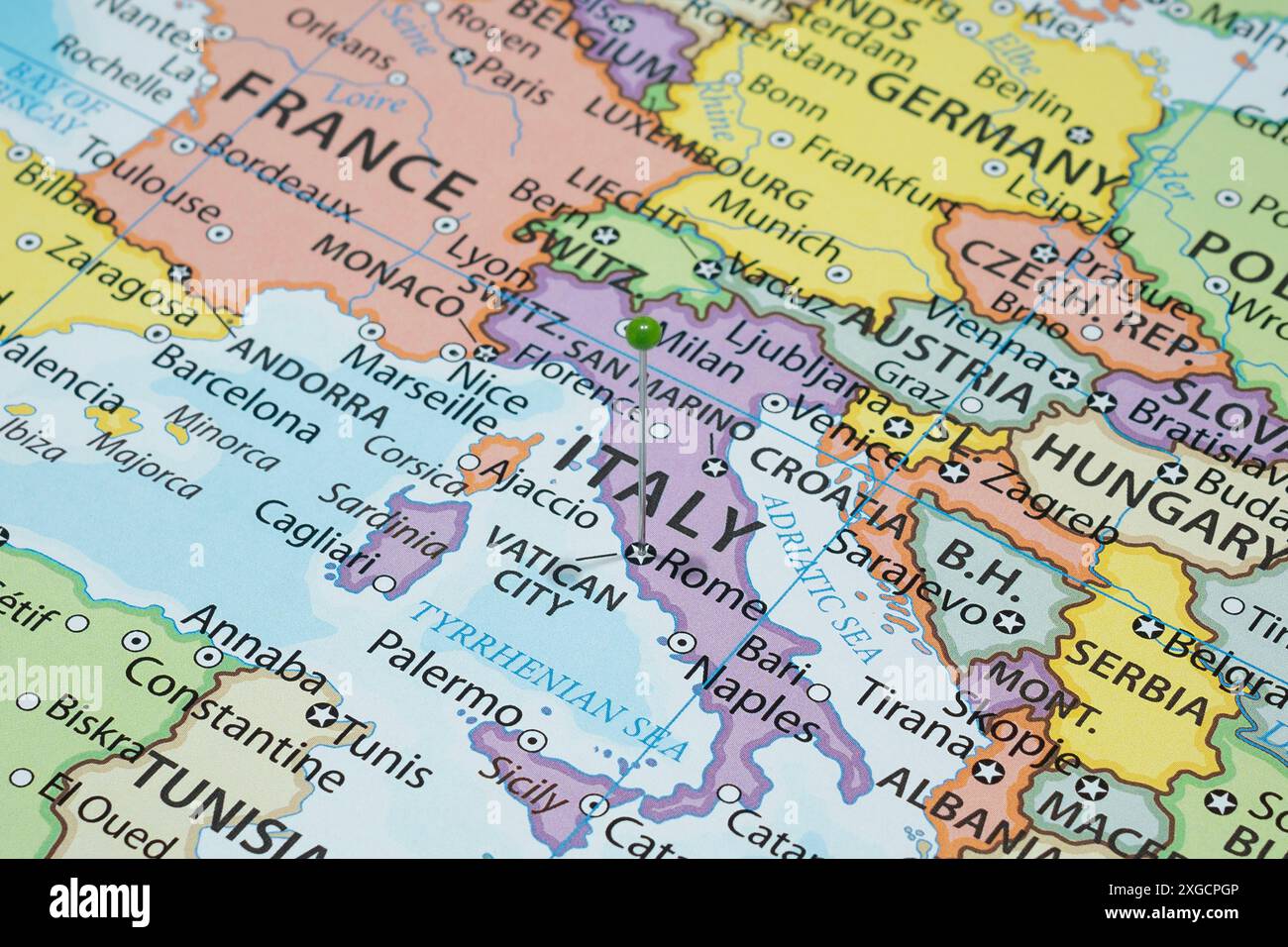 Close up to a Rome with a Green pin needle into Italy country political ...