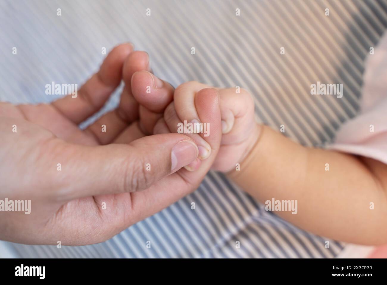 Asian parent hands holding newborn baby fingers, Closeup mother’s hand ...