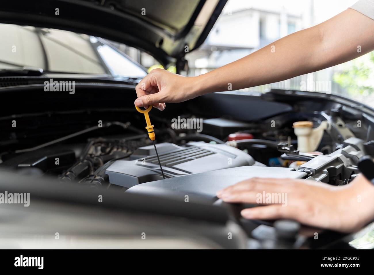 Close-up photo of woman's hand check engine oil A woman pulls out the ...