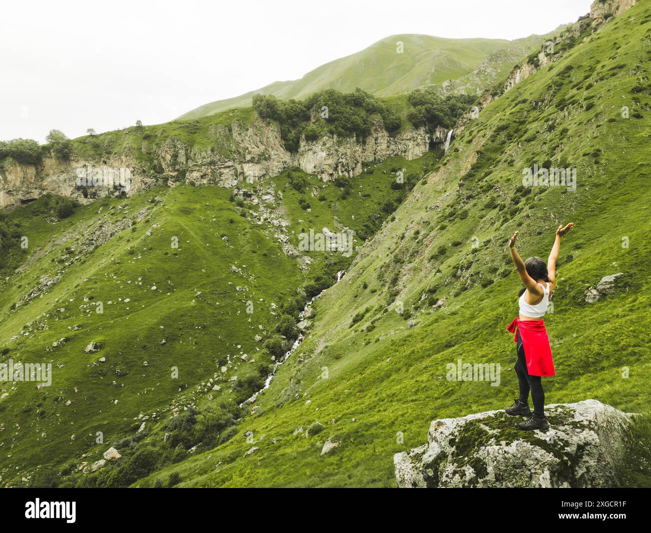 Aerial view happy woman tourist hiker standing on the top of mountain ...