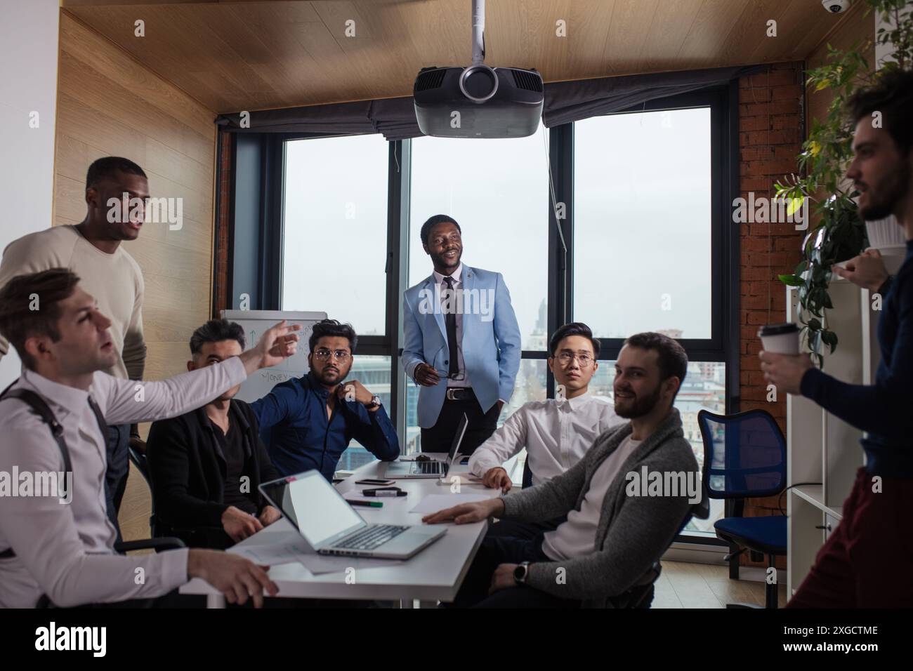 Businessman in blue formal suit standing and leading business meeting ...